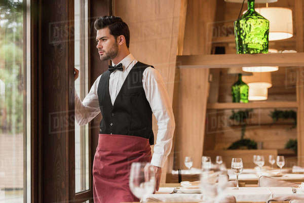 Handsome Waiter standing and looking at window - Royalty-free Stock ...