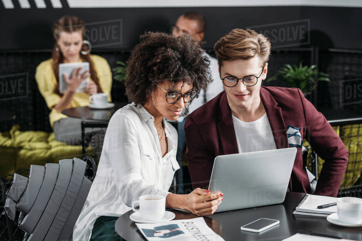 Business people working together with laptop at cafe - Royalty-free ...