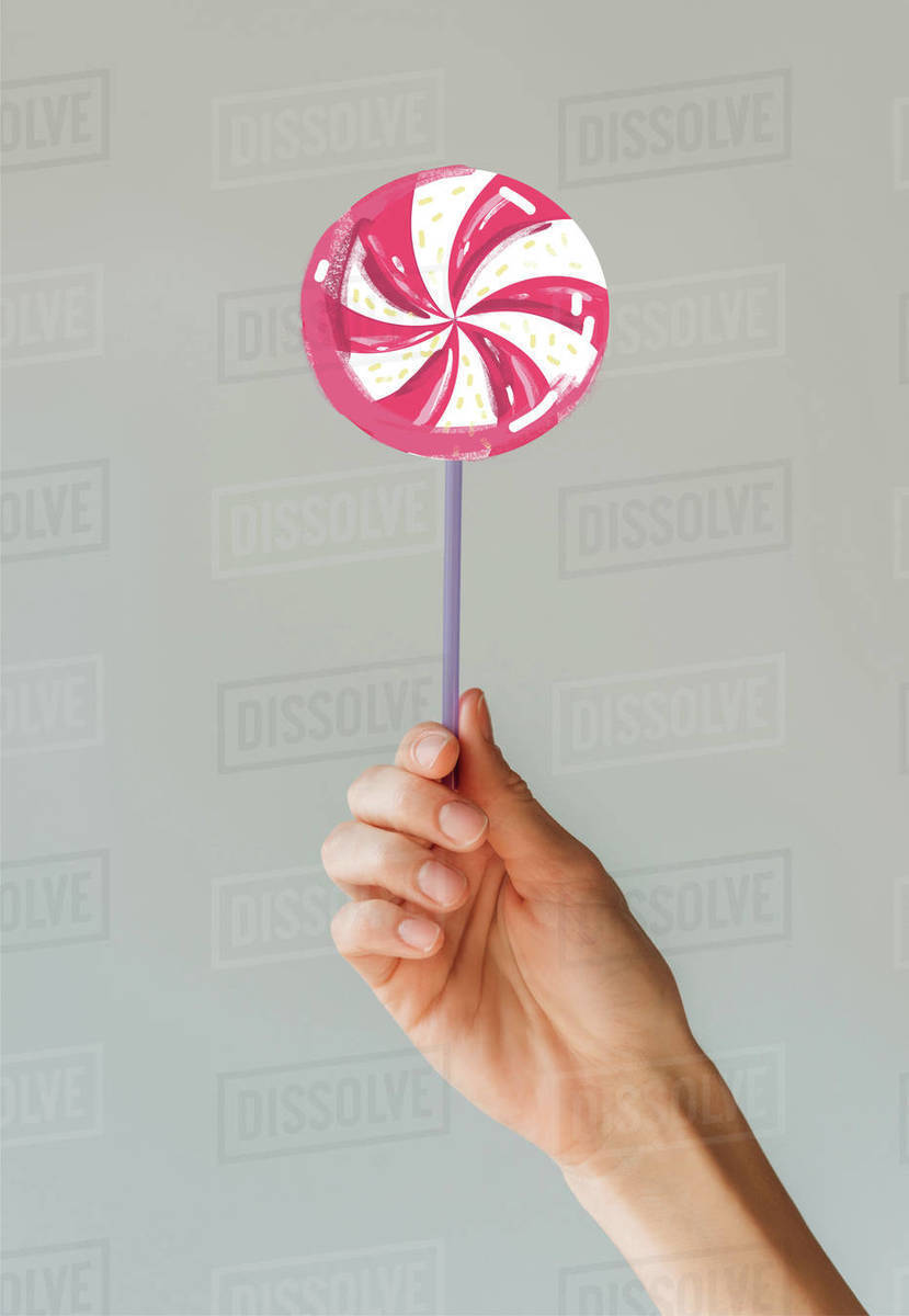 Cropped image of woman holding green lollipop in her hand isolated on ...
