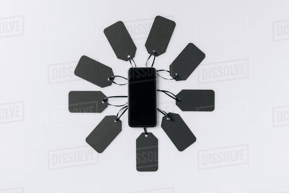 Top view of smartphone and arranged black blank tags isolated on white ...