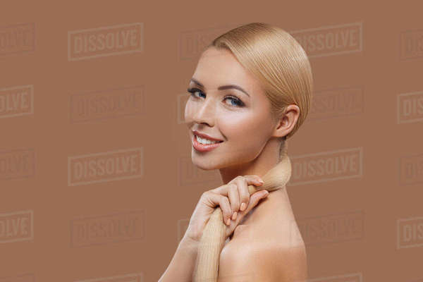 Side view of smiling beautiful blonde hair girl isolated on beige ...