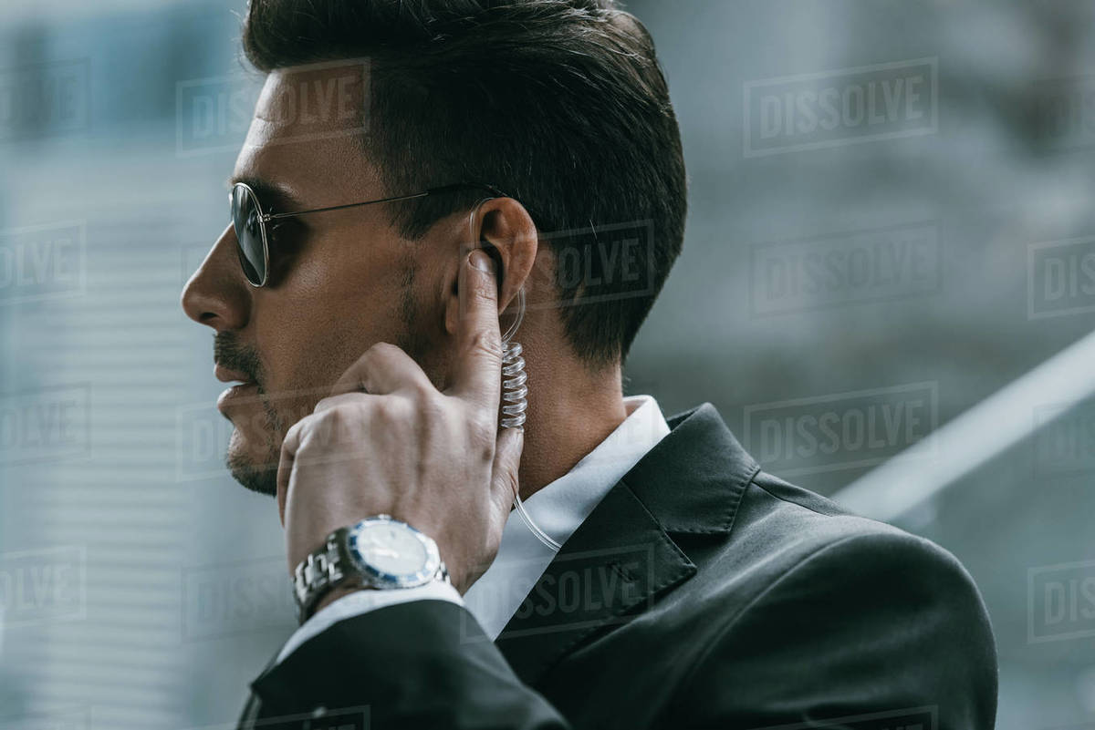 Handsome security guard standing and listening message with security ...