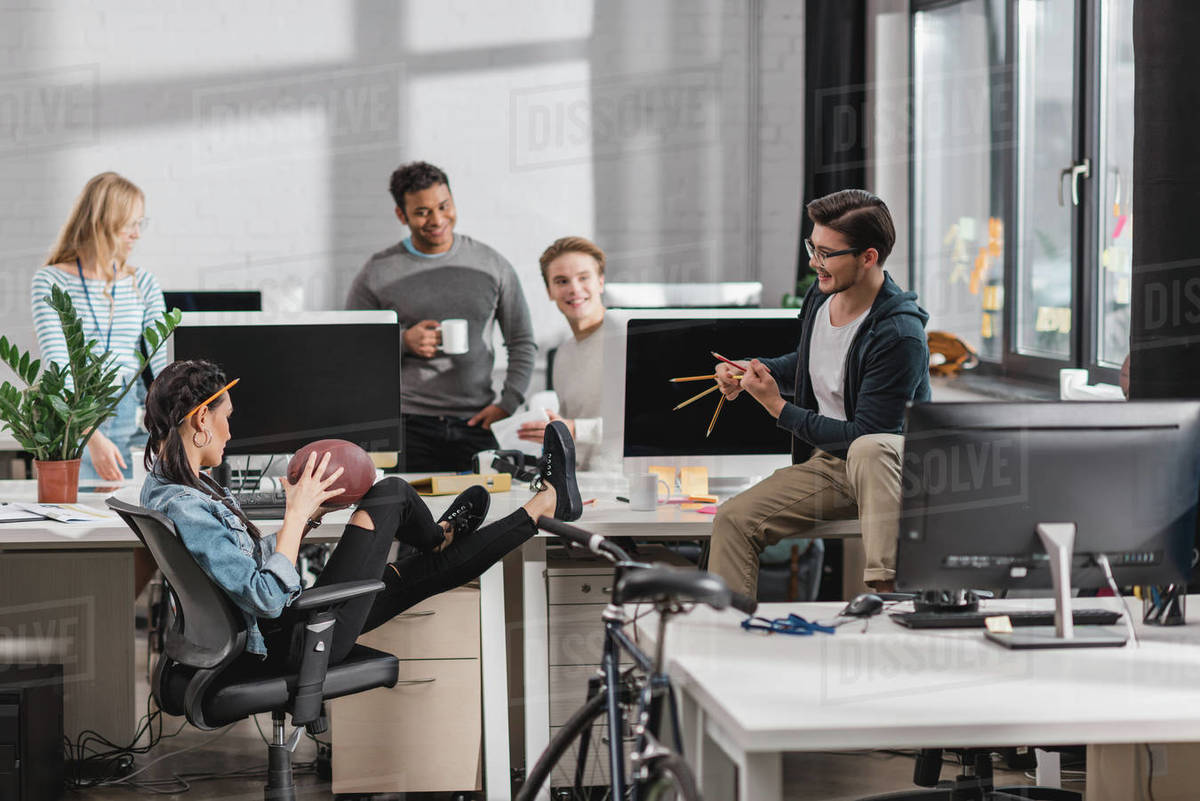 Happy colleagues having fun at modern office - Stock Photo - Dissolve