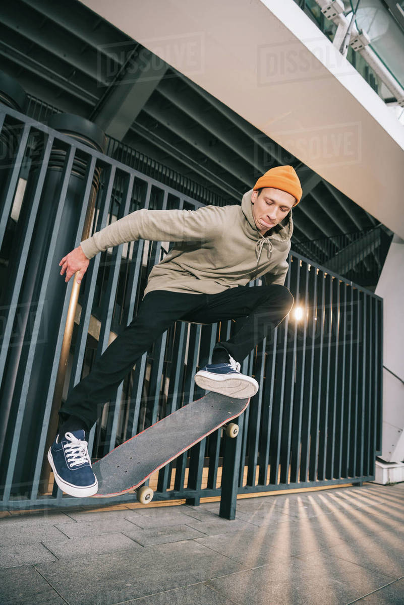 Professional skateboarder performing jump trick in urban location ...