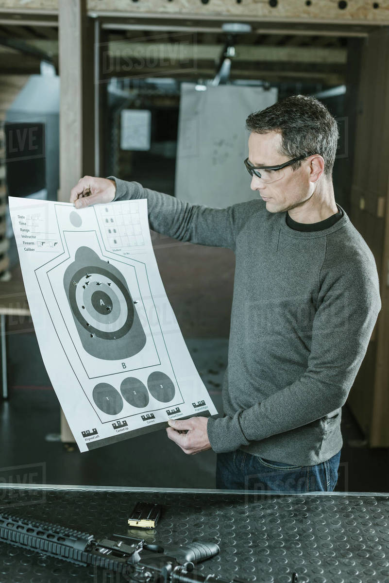 Shooter looking at used target after shooting in gallery - Stock Photo ...