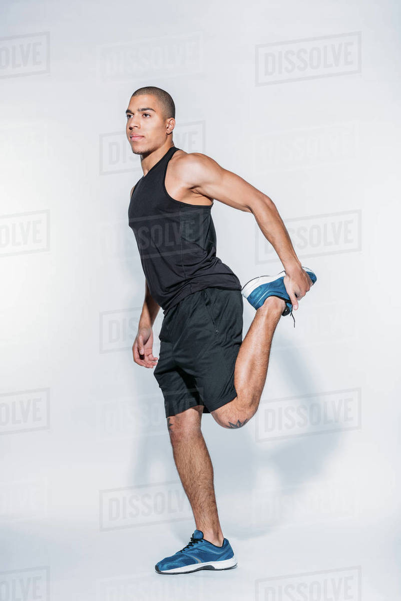 african american sportive man stretching legs - Stock Photo - Dissolve
