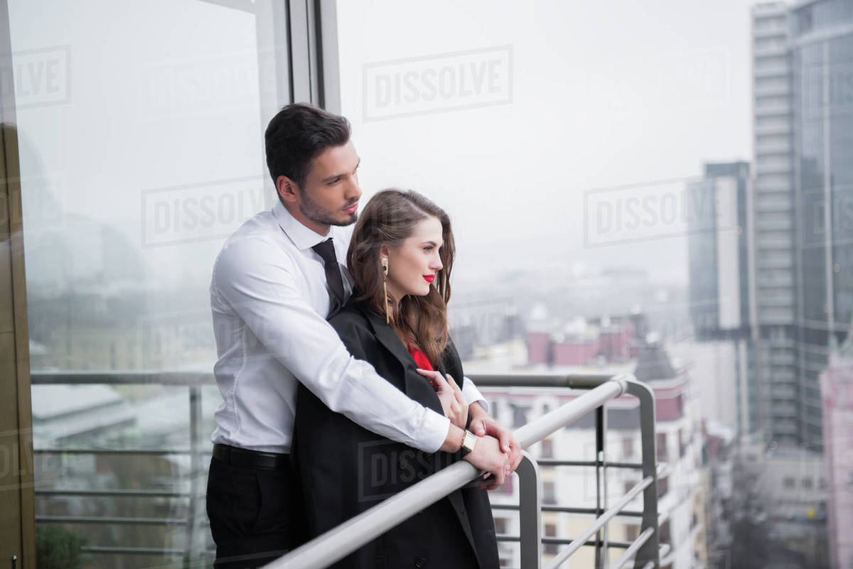 Young couple in love standing on balcony together - Stock Photo - Dissolve