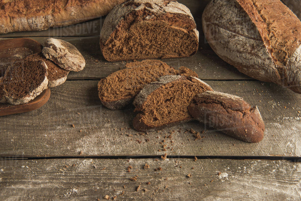 Top view of sliced and whole loaves of fresh homemade bread on rustic ...