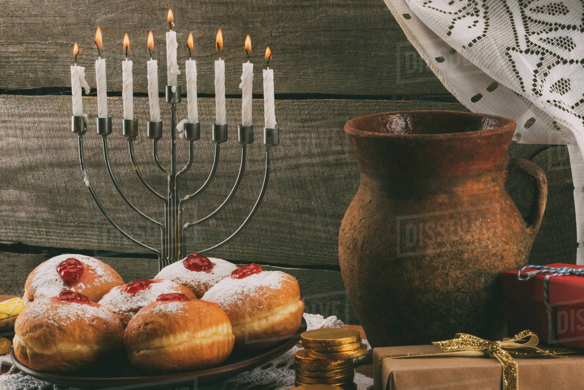 Traditional jewish menorah, ceramic jug, gifts and donuts for hanukkah ...