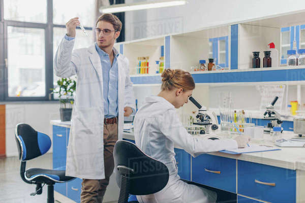 Biologists in white coats working with tubes in lab - Royalty-free ...