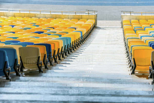 Rows of yellow and blue stadium seats and stadium stairs - Royalty-free ...