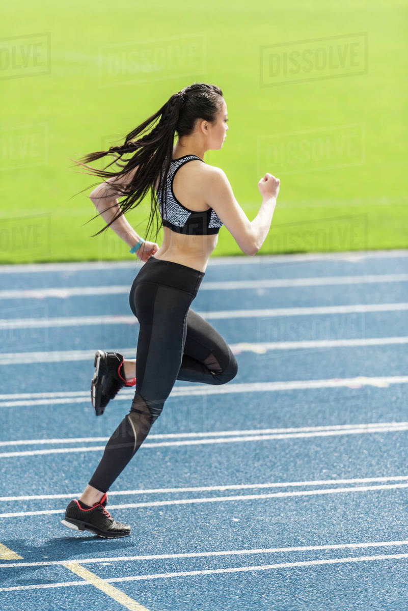 Asian sportswoman training on running track stadium, young girl running ...