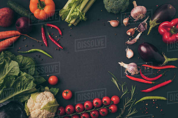 Top view of unprocessed vegetables on a gray table - Stock Photo - Dissolve