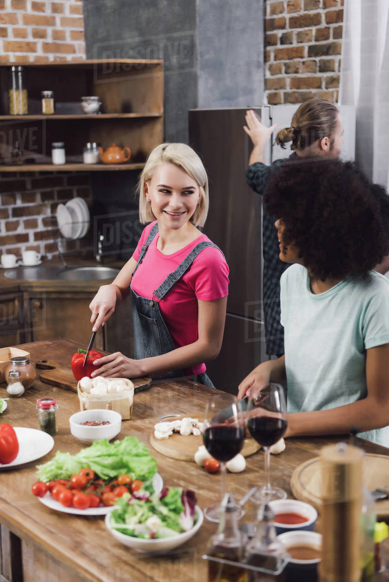 Smiling multiethnic girls cooking in kitchen - Royalty-free Stock Photo ...