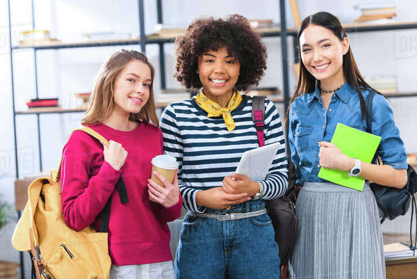 Portrait of smiling multiethnic students with backpacks - Royalty-free ...