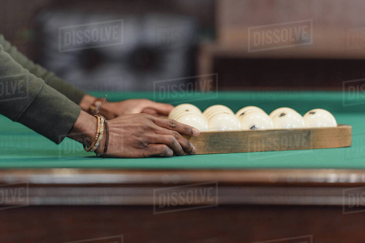 cropped image of male hands forming balls set by triangle on pool ...
