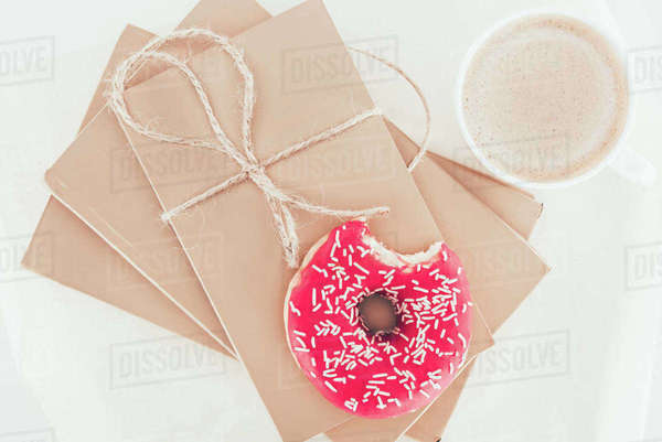 Top view of doughnut on wrapper packages with cup of coffee - Royalty ...
