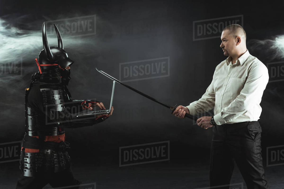 Side view of man with katana standing in front of samurai while he ...