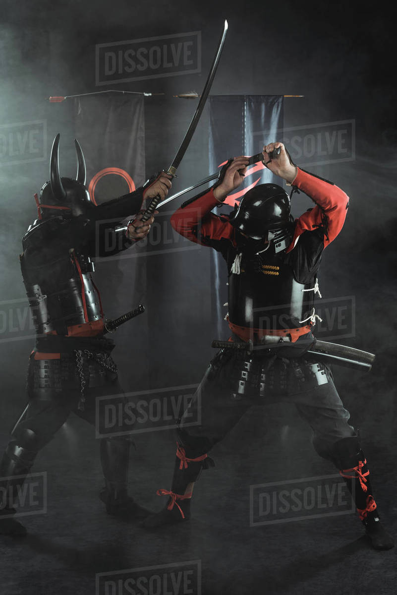 Traditional armored samurai fighting with swords on black - Royalty ...