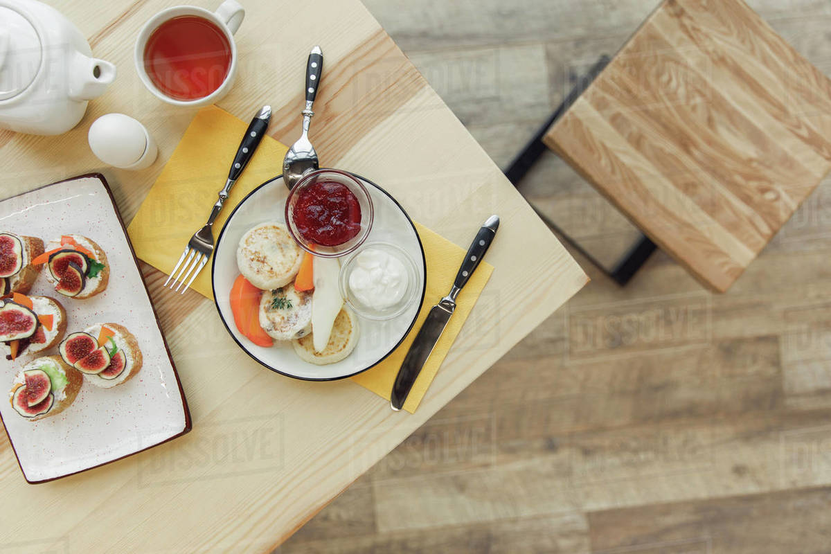 Top view of healthy delicious breakfast with tea set on wooden table ...