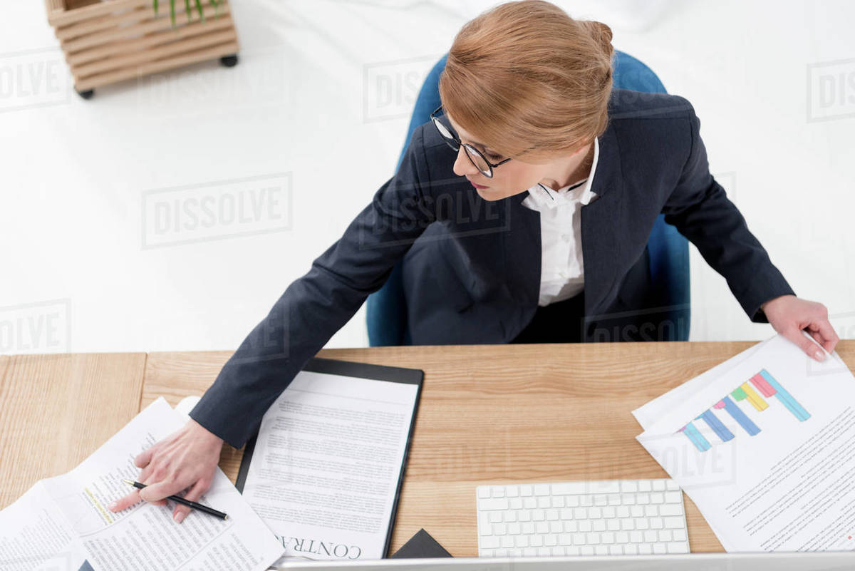 overhead view of businesswoman doing paperwork at workplace in office ...