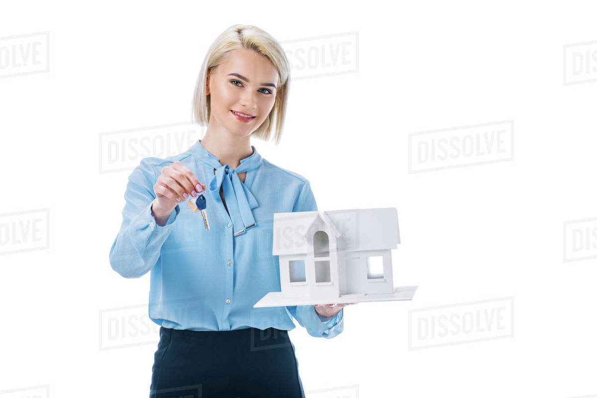 Beautiful smiling realtor holding key and house model, isolated on ...
