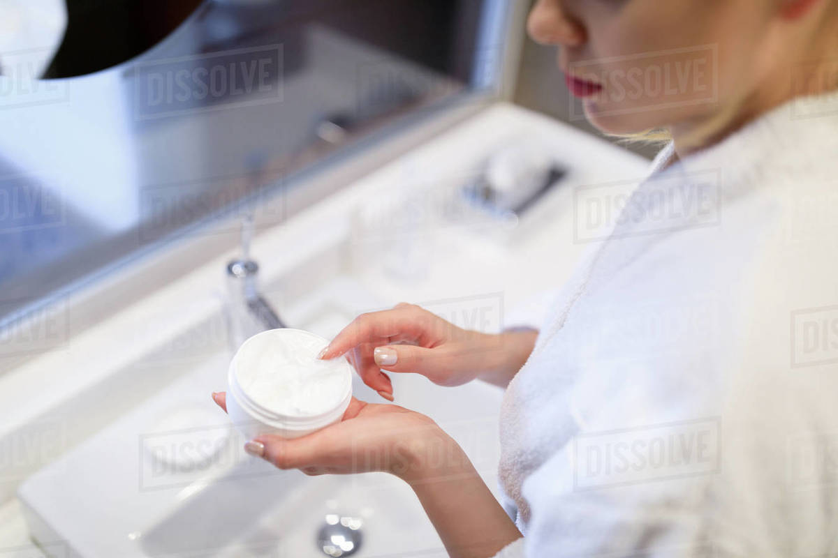 cropped image of girl taking cream - Royalty-free Stock Photo | Dissolve