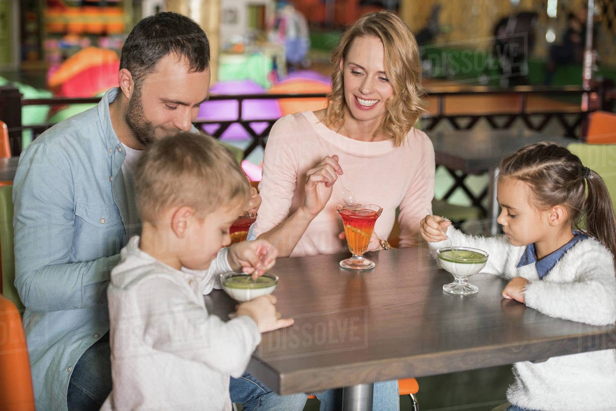 happy family eating sweet desserts together in cafe - Royalty-free ...