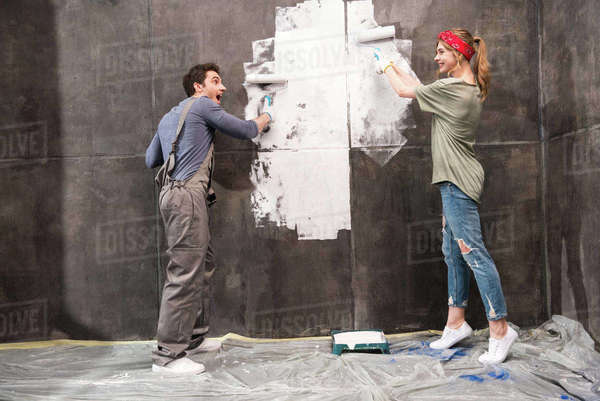 Young couple painting wall together, renovation home concept - Stock ...