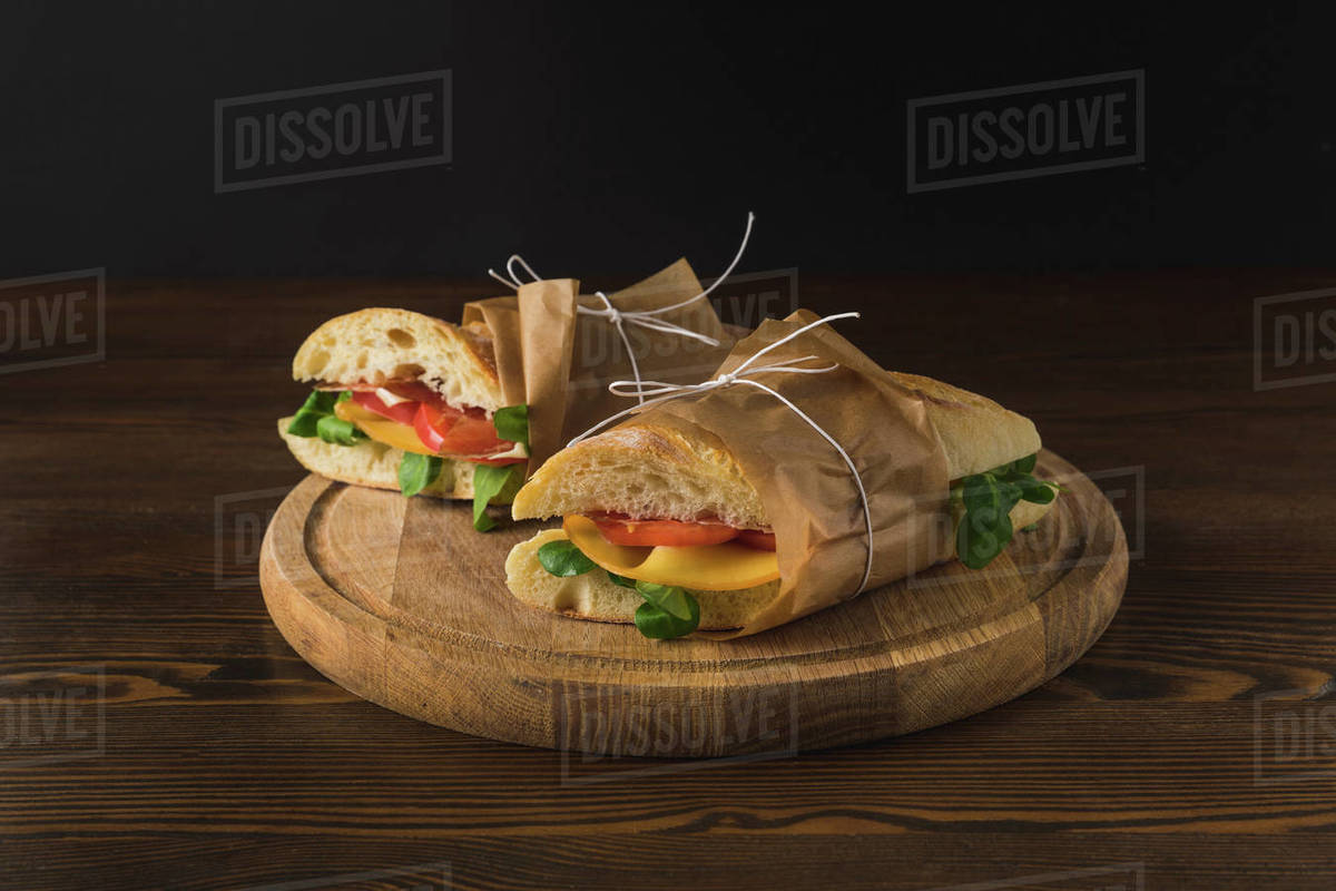 Two cooked delicious panini with vegetables on wooden board - Royalty ...