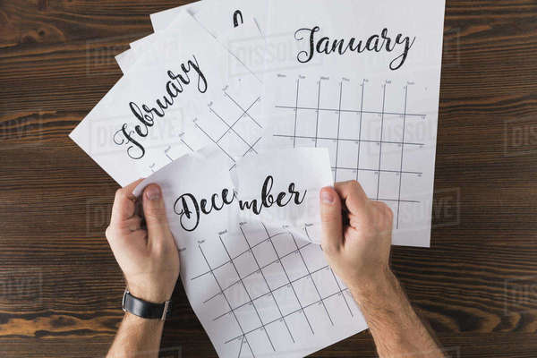 Cropped shot of man tearing calendar on wooden tabletop - Royalty-free ...