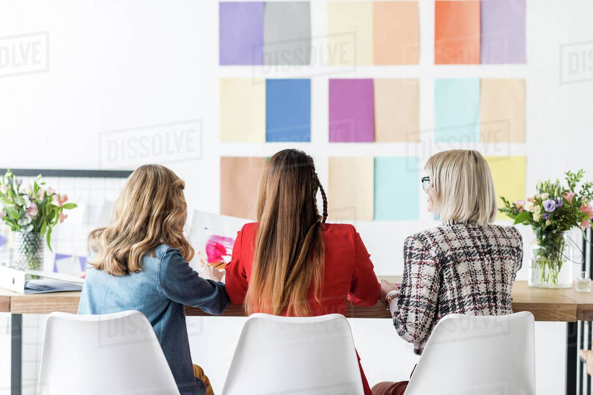 Back view of magazine editors working with color palette an wall ...