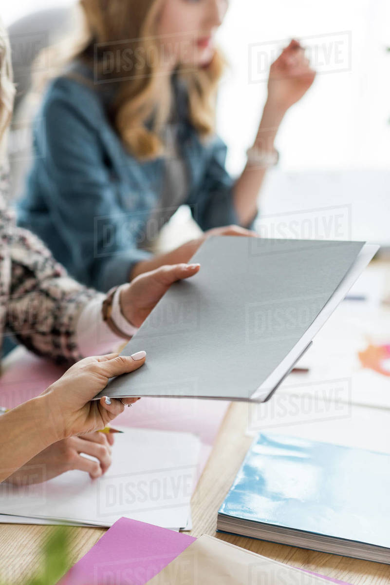 Cropped view of magazine editors working with documents in modern ...