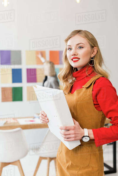 Attractive magazine editor with folder in modern office with colleague ...