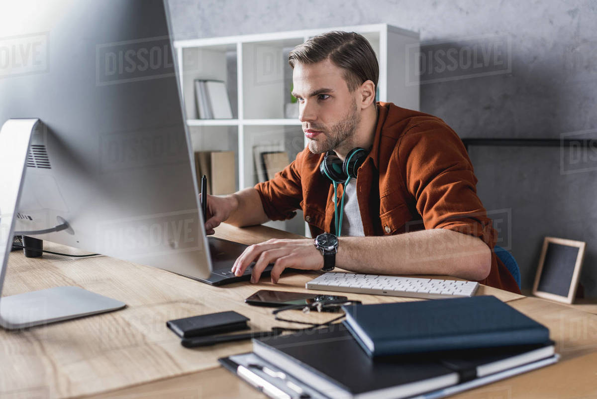 handsome young man working with computer at modern office - Royalty ...
