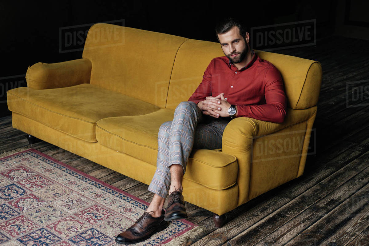 Fashionable elegant man sitting on yellow couch - Royalty-free Stock ...