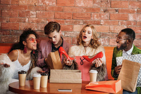 Fashionable multiethnic young people looking at trendy red high heeled ...