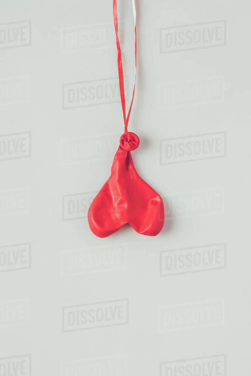 Top view of flipped over deflated balloon on ribbon isolated on white ...