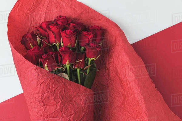 Top view of bouquet of roses in red wrapping paper isolated on white ...