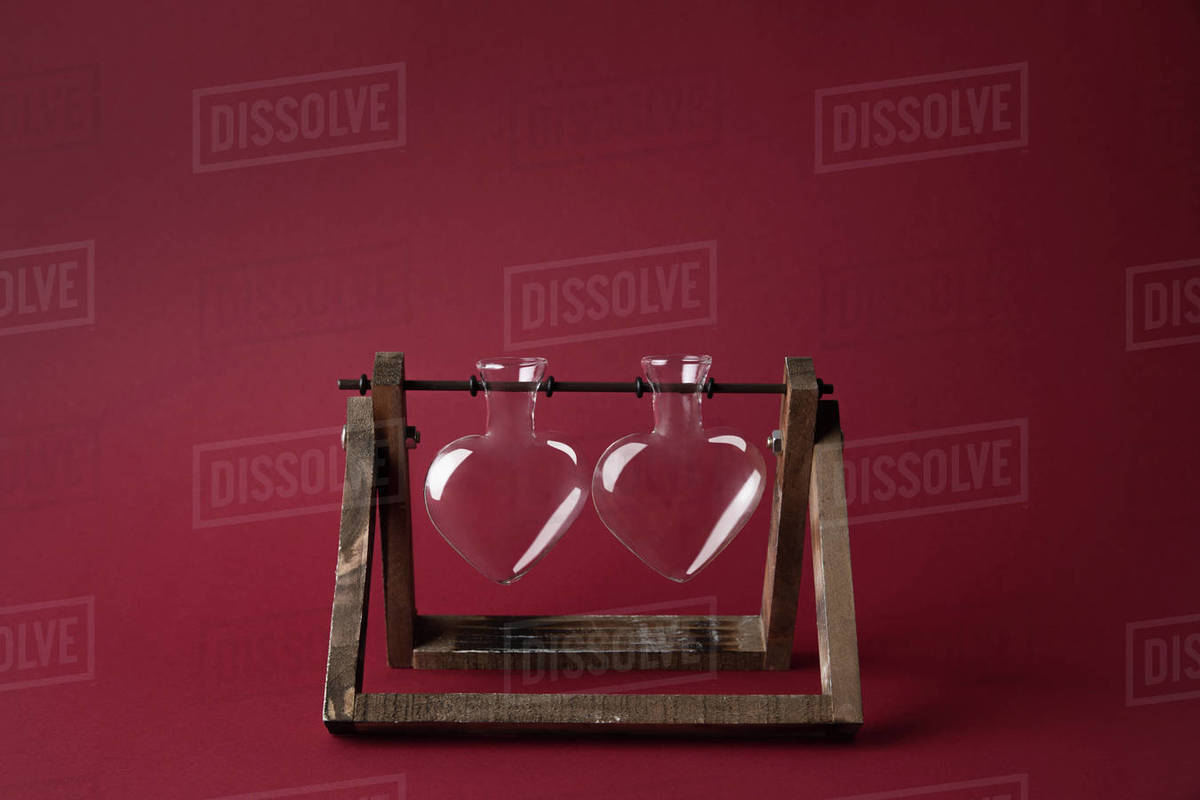 Two empty heart shaped glass jars on wooden stand on red - Royalty-free ...