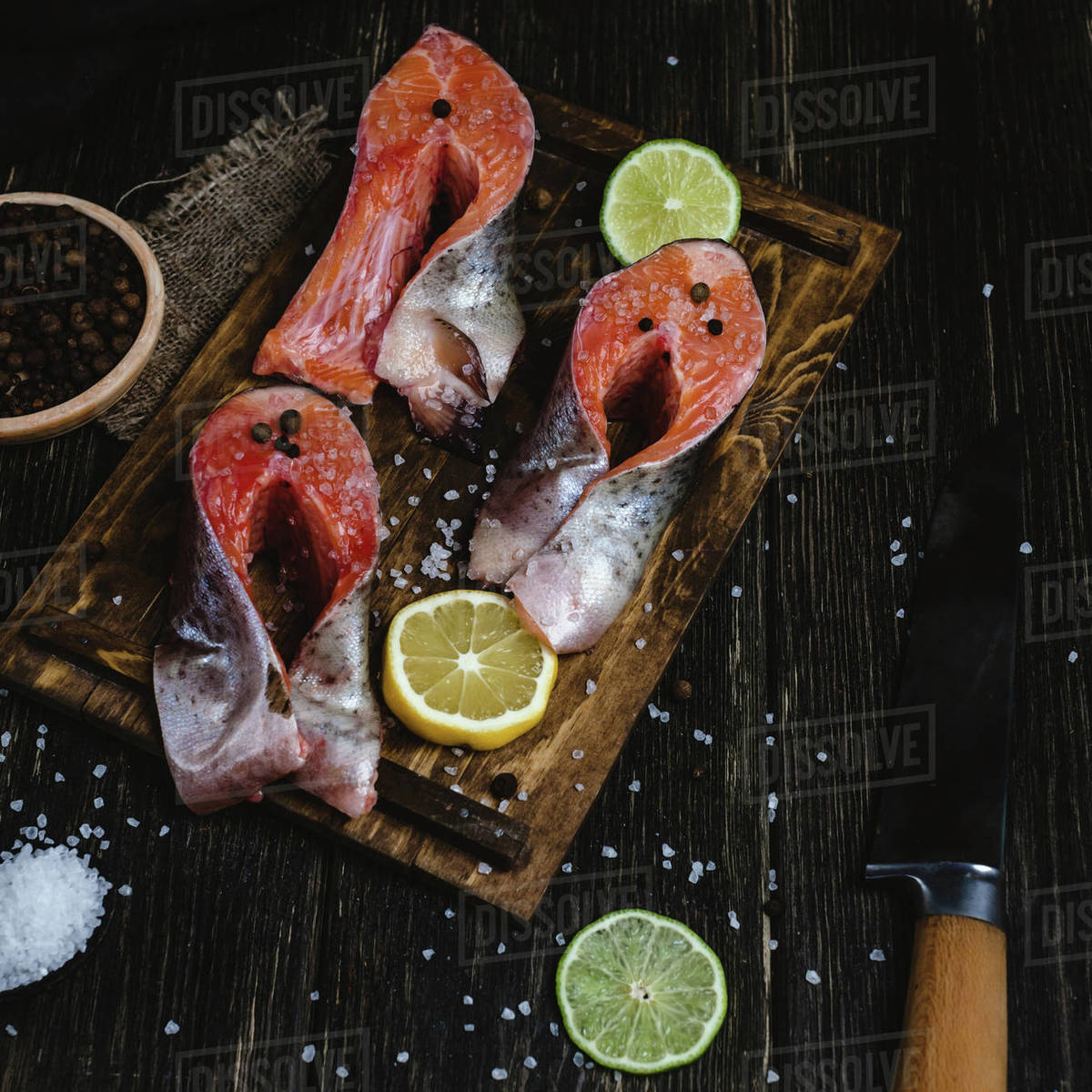 Close-up view of fresh sliced red fish with spices and citrus fruits ...