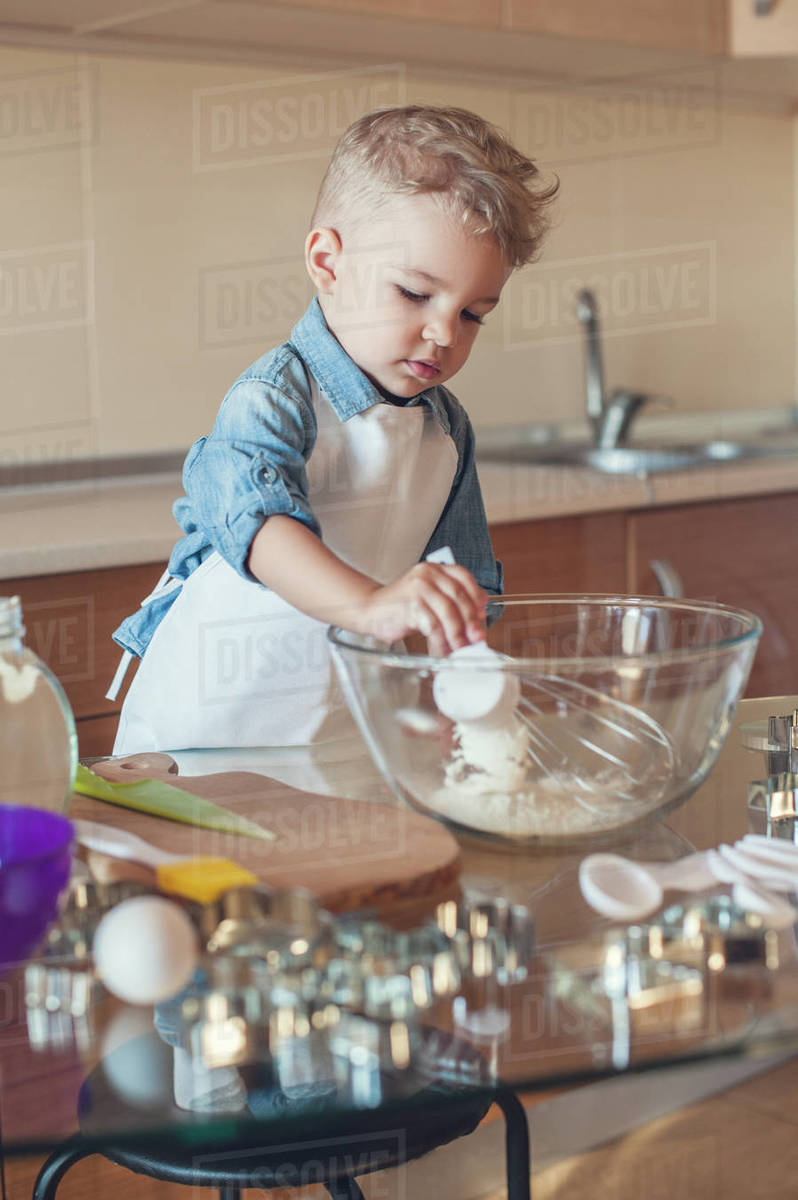 Adorable boy adding flour to glass bowl - Royalty-free Stock Photo ...