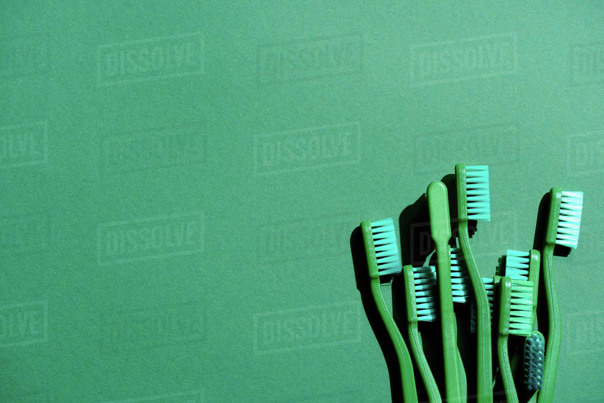 Top view of green toothbrushes, on green with copy space - Royalty-free ...