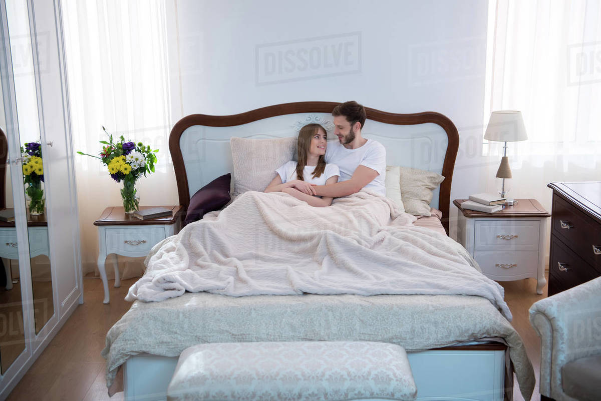 Happy couple hugging in bedroom with design interior - Royalty-free ...