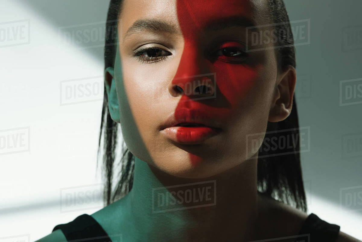 Portrait of african american seductive stylish model with red shadow on ...