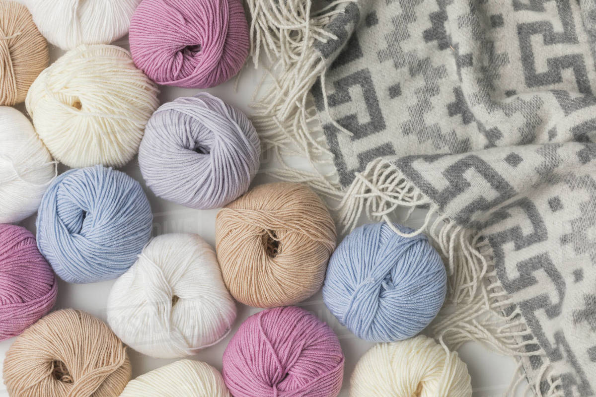 Scattered colored yarn balls and blanket on white background - Stock ...