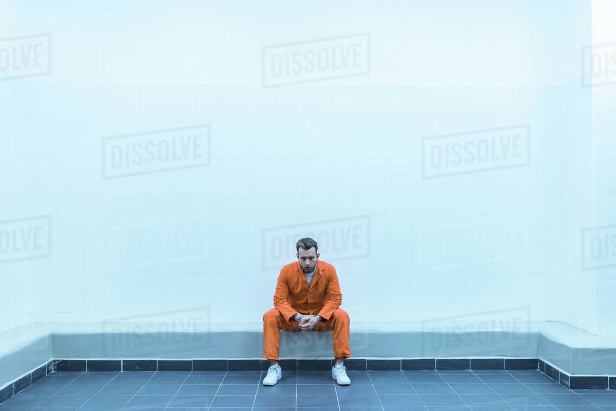 Prisoner sitting on bench in prison room - Royalty-free Stock Photo ...