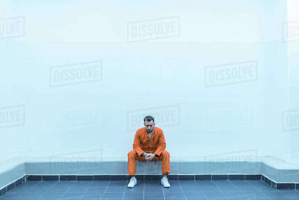 Prisoner sitting on bench in prison room - Royalty-free Stock Photo ...