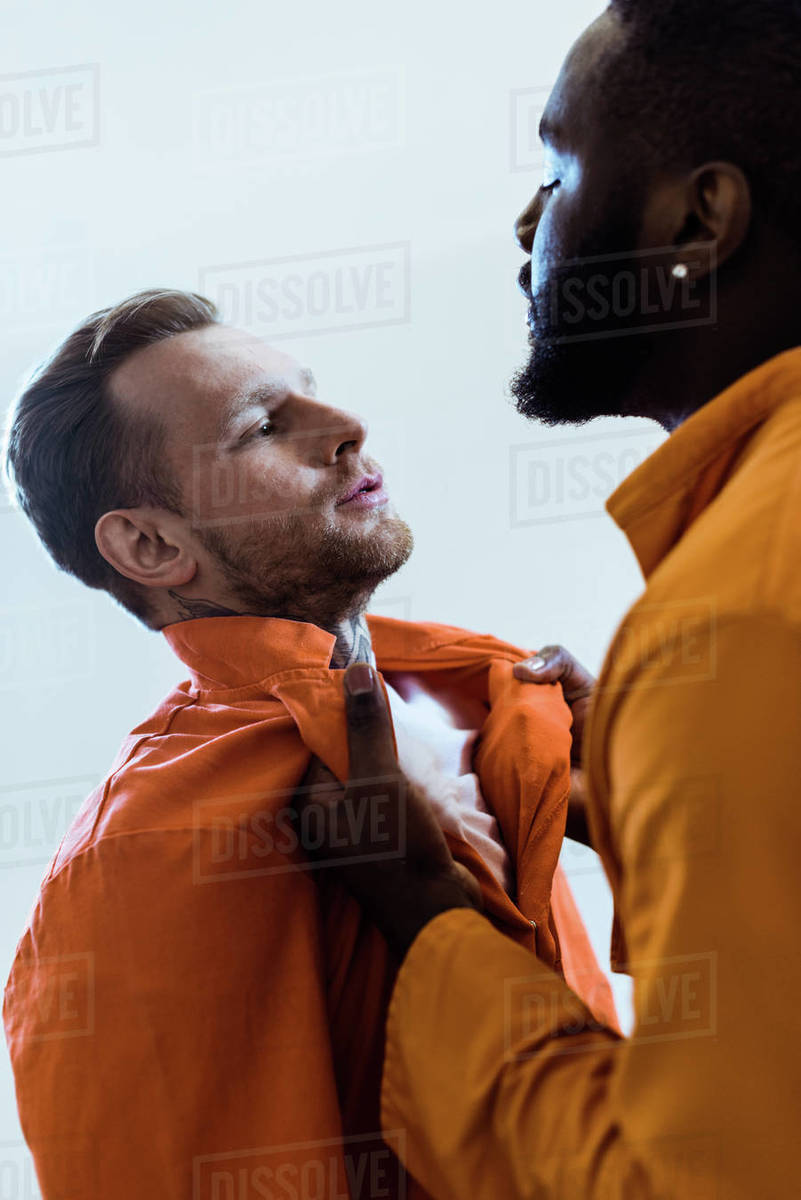African American prisoner threatening cellmate isolated on white ...