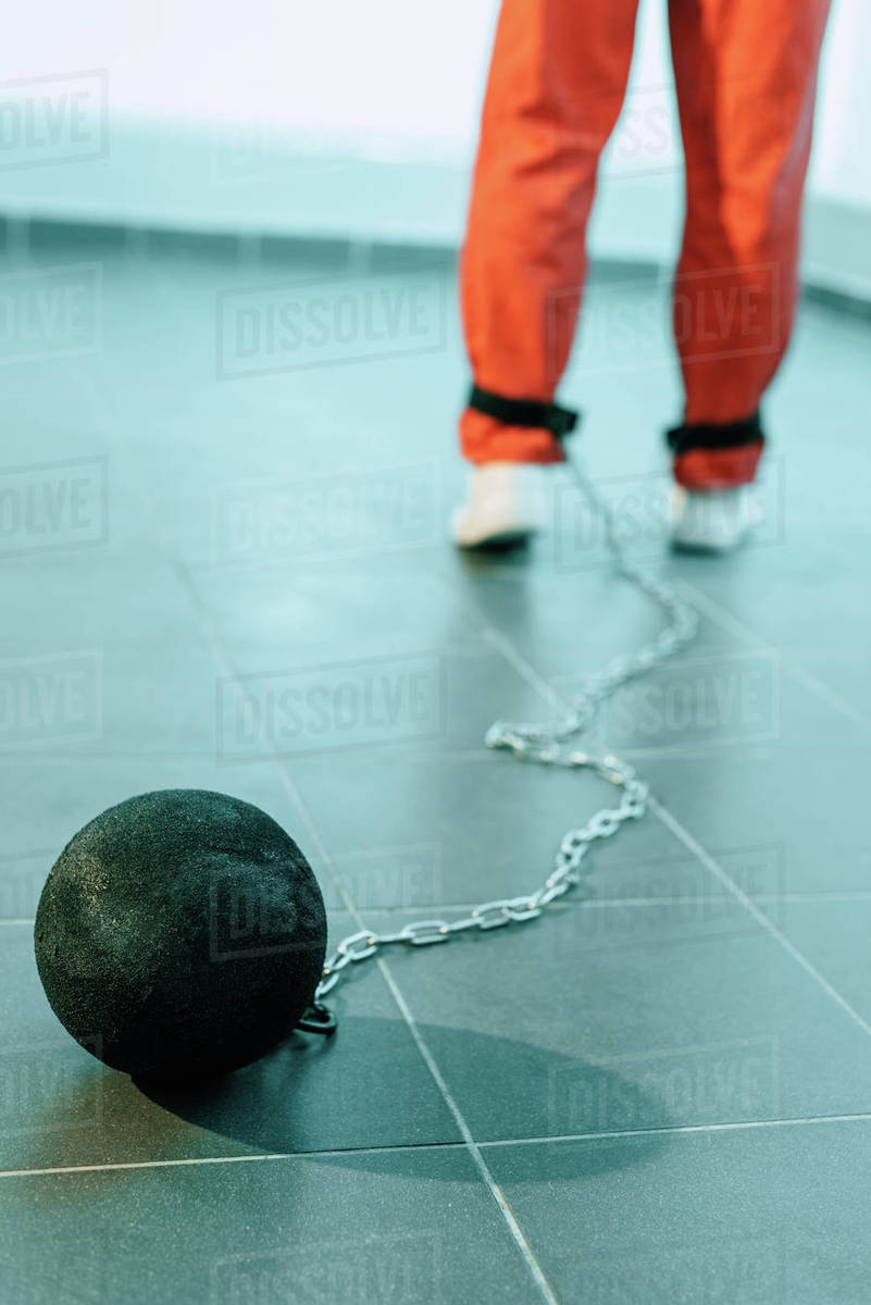 cropped image of prisoner in orange uniform with weight tethered to leg ...
